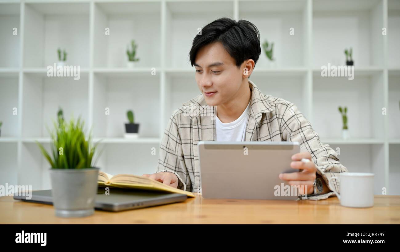 Attractive Asian male college student in library co-working space ...