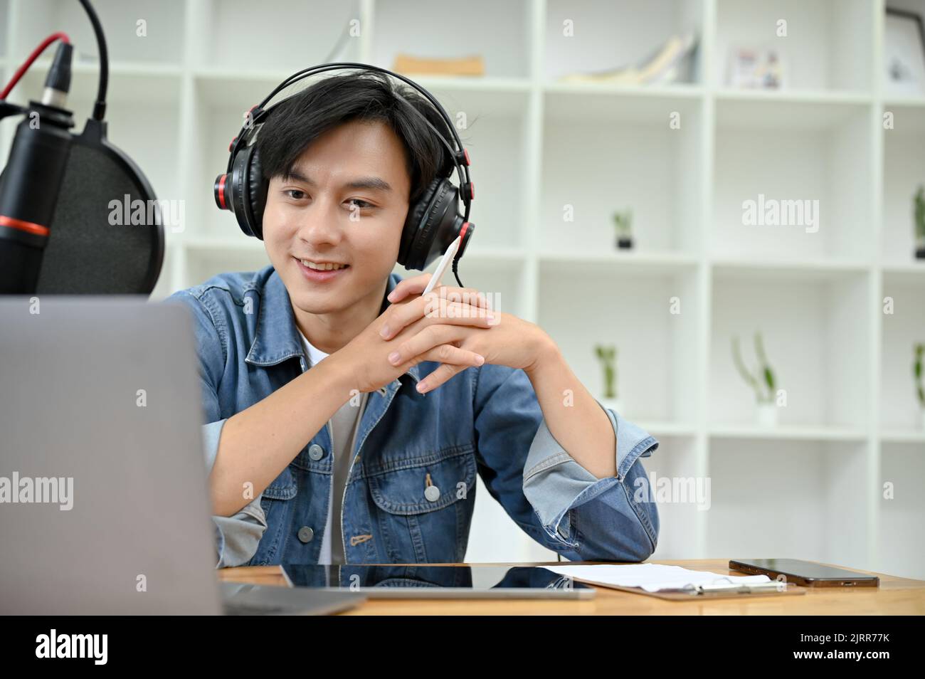 Handsome young Asian man radio host recording and broadcasting his ...