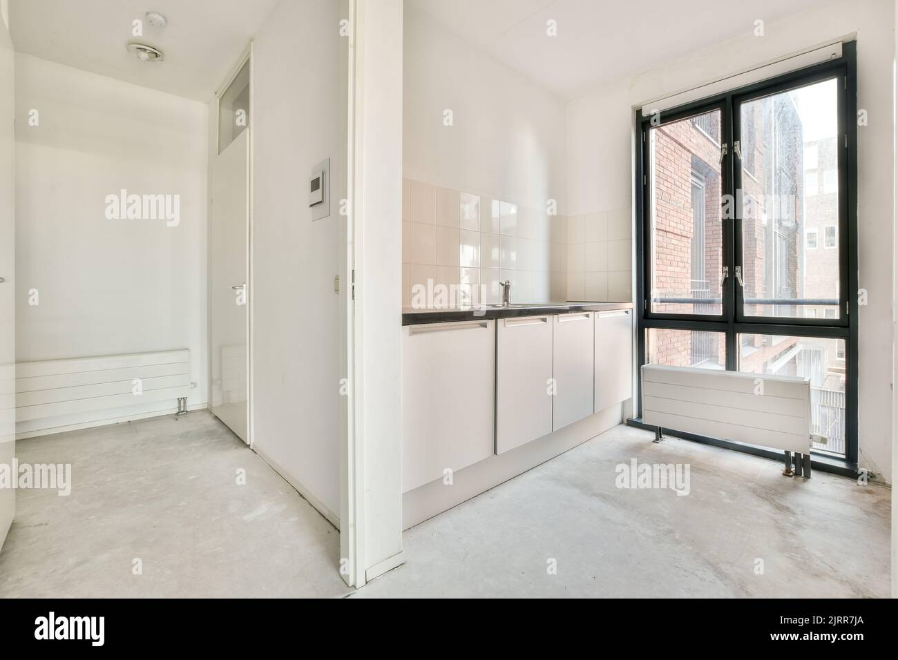 Interior of empty white kitchen with windows and wooden parquet floor ...
