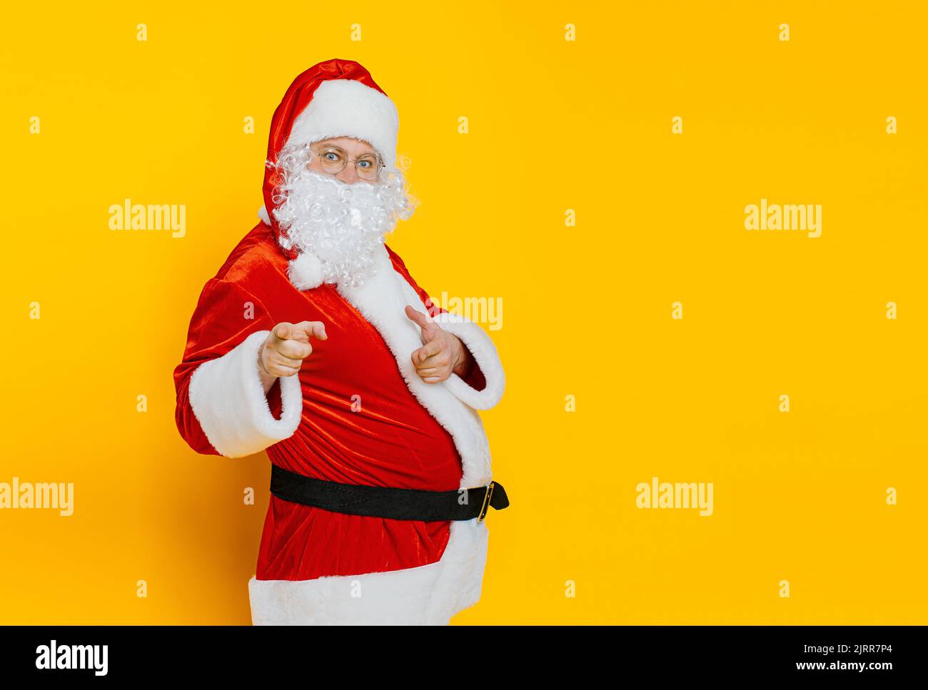A man in a santa costume points with his index fingers at the camera on ...