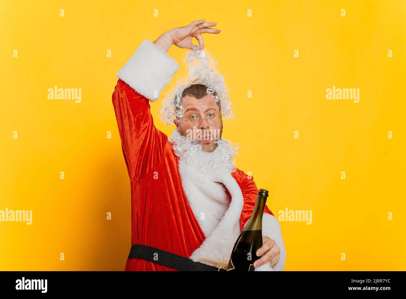 Drunk man in a sata suit with a bottle of champagne in his hand ...