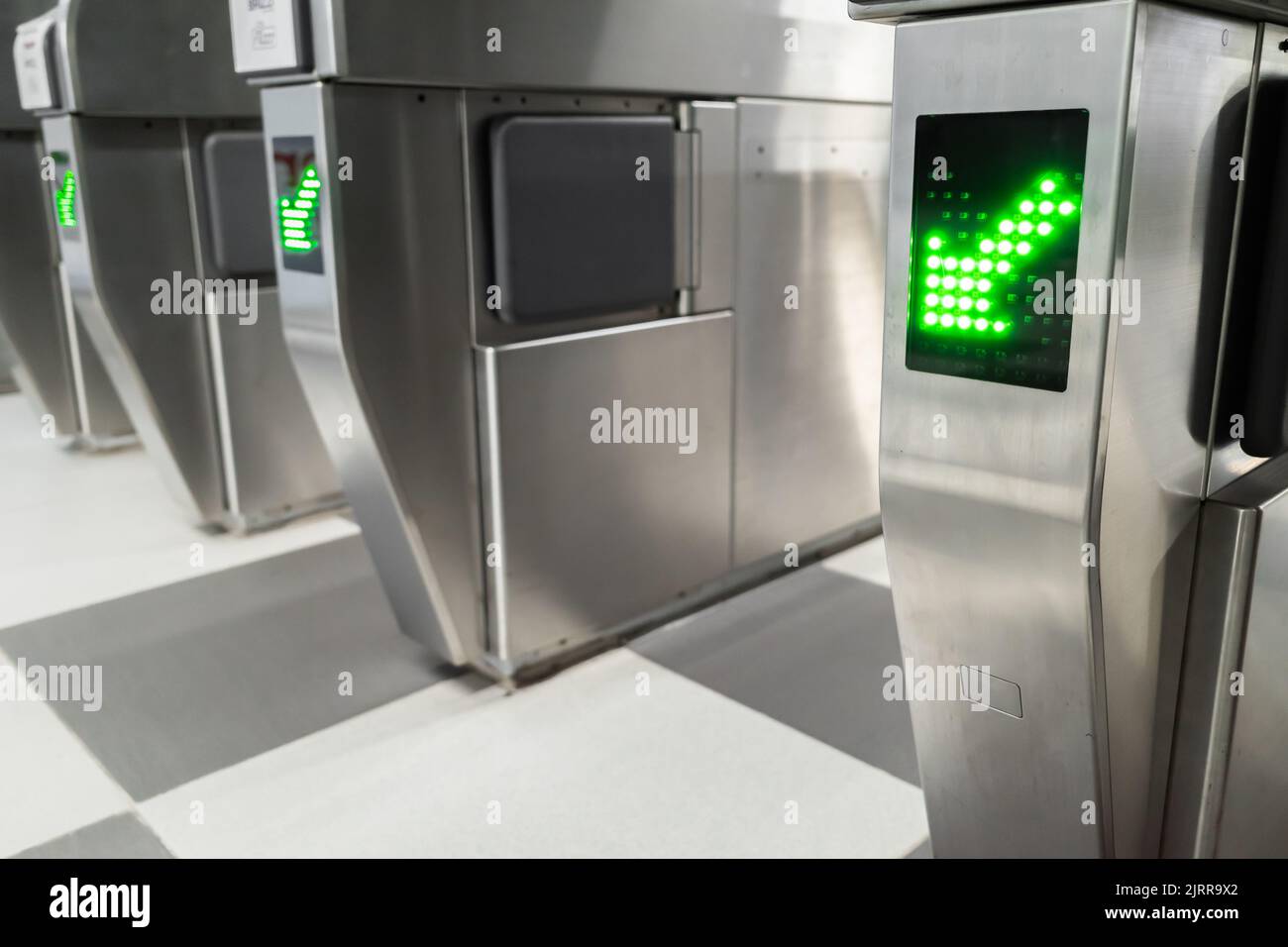 Entrance gate with green arrow direction sign on metro subway station ...