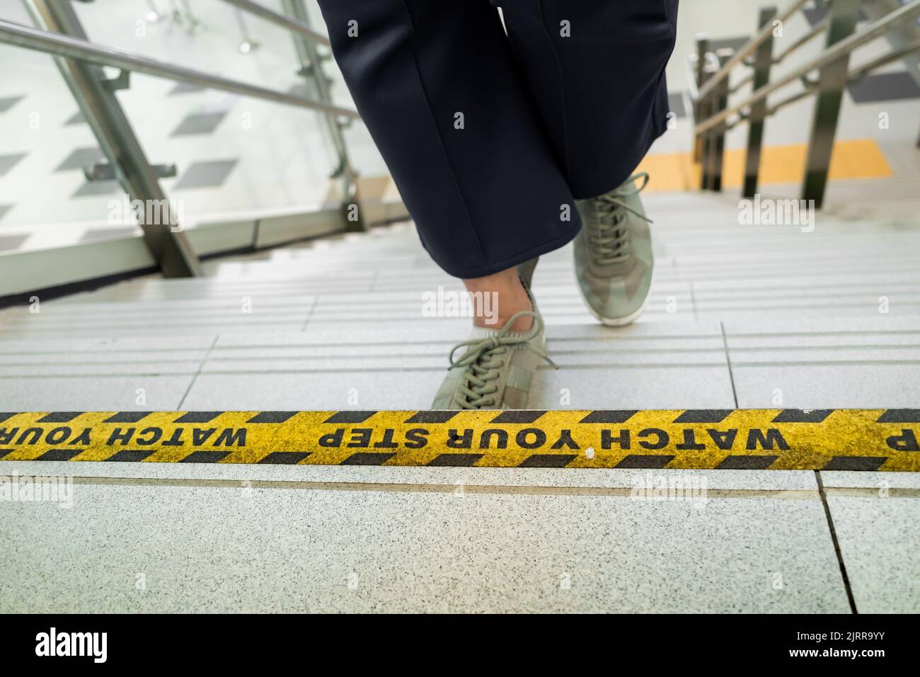 Watch your step sign sticker on the stairs at public area with a person ...