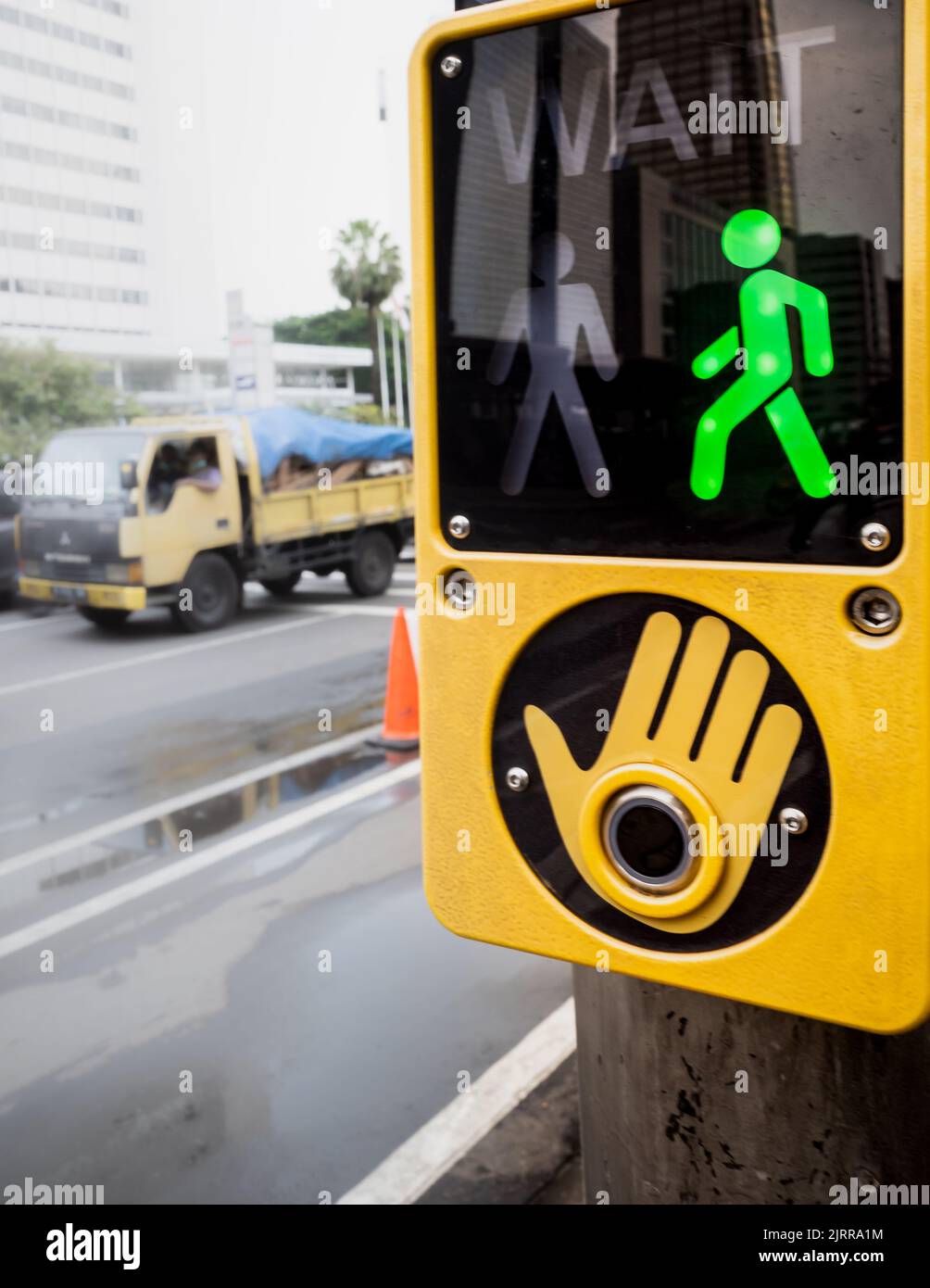 Walk signal sign located at pedestrian crosswalk area on a busy city ...