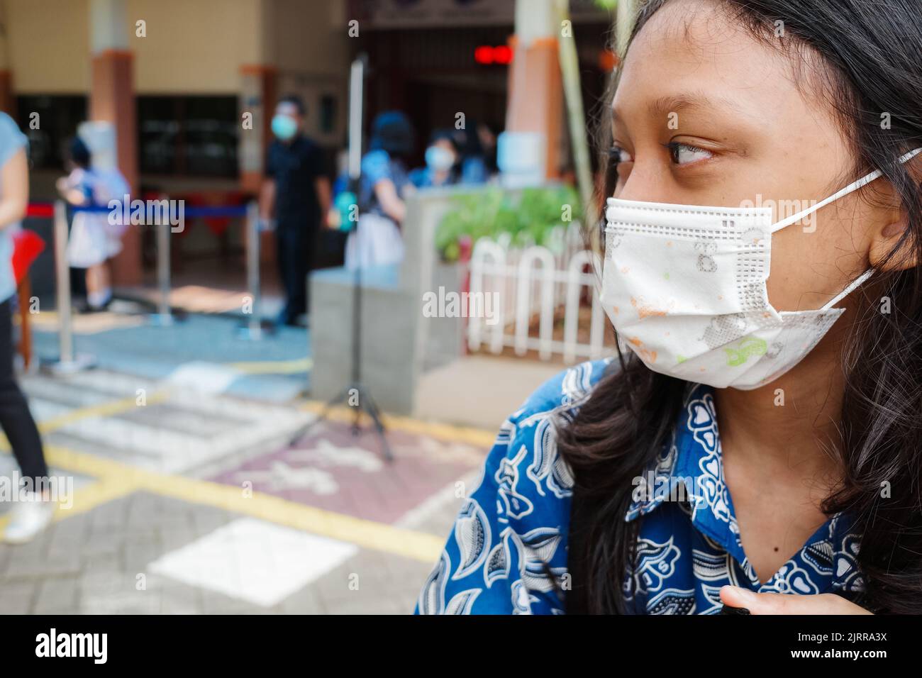 Southeast Asian schoolgirl wearing face mask back to school again after ...