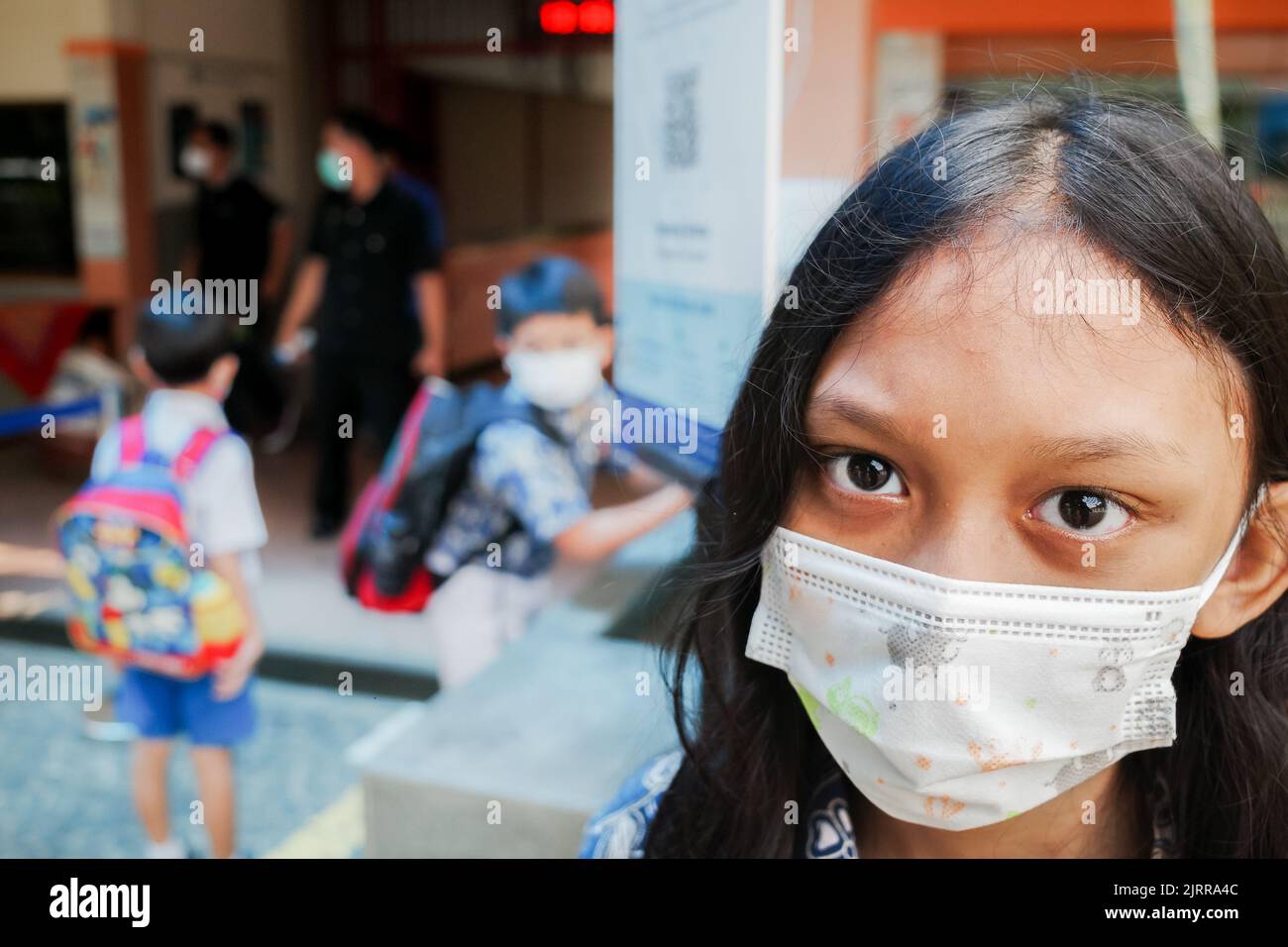 Southeast Asian elementary schoolgirl wearing face mask back to school ...