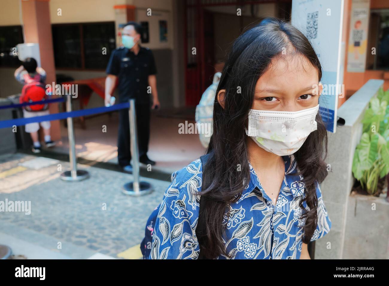 Southeast Asian elementary schoolgirl wearing face mask back to school ...