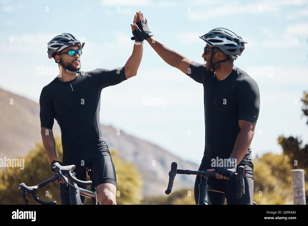 High five, winner and cycling team of cyclists having fun riding ...