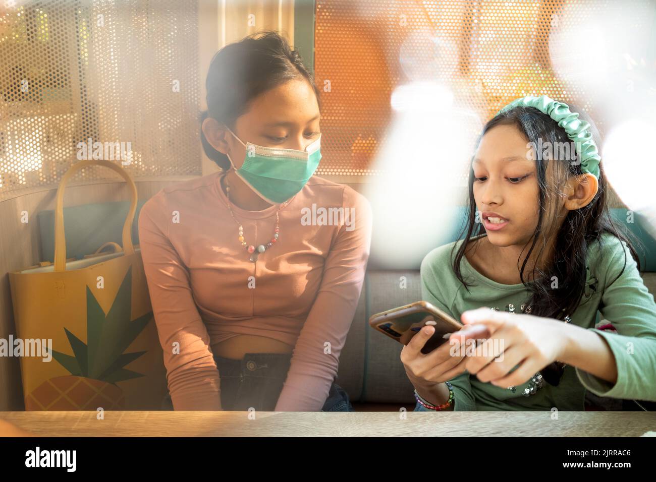 Two Southeast Asian teen girls hangout together at a restaurant with ...