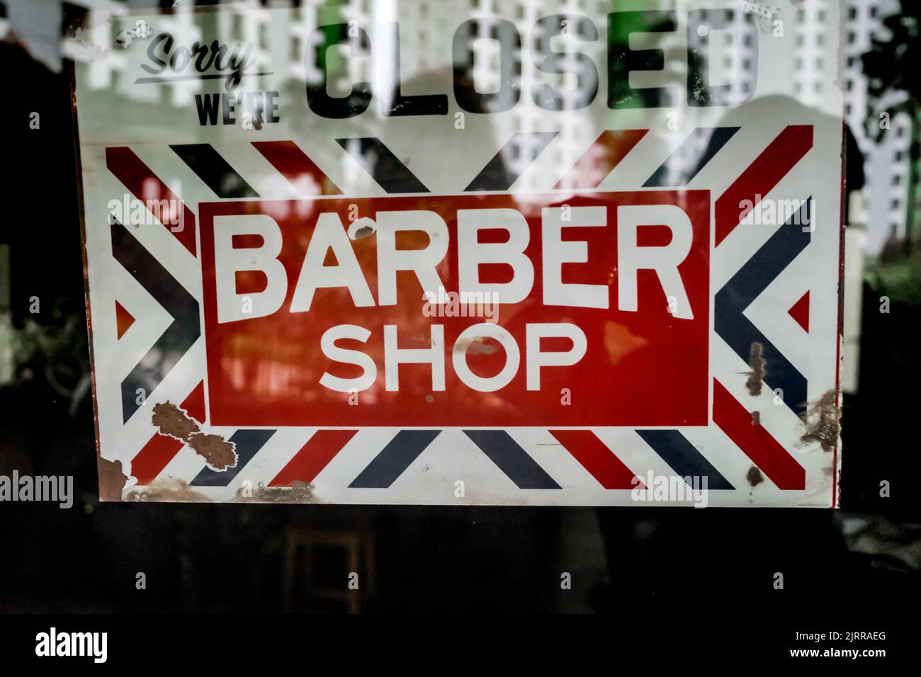 Closed door sign on a barber shop glass door. Red white navy sorry we ...