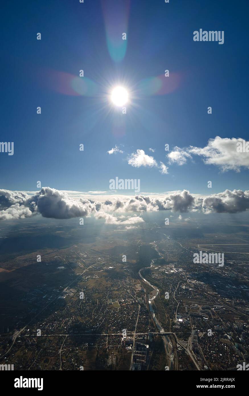 Aerial view from airplane window at high altitude of distant city ...