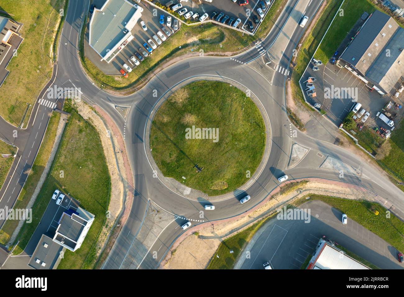Aerial view of road roundabout intersection with moving heavy traffic. Urban circular ...