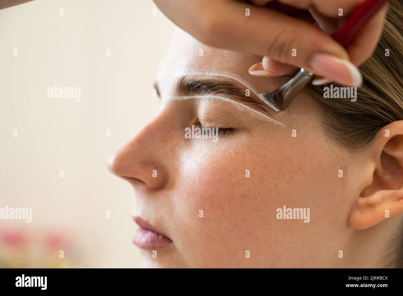 The master draws the shape of the eyebrows with white paint before ...