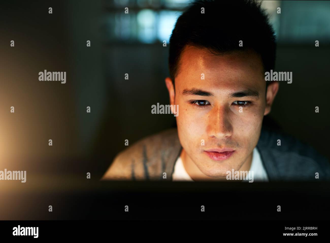 Working late into the night. a handsome young male programmer working ...