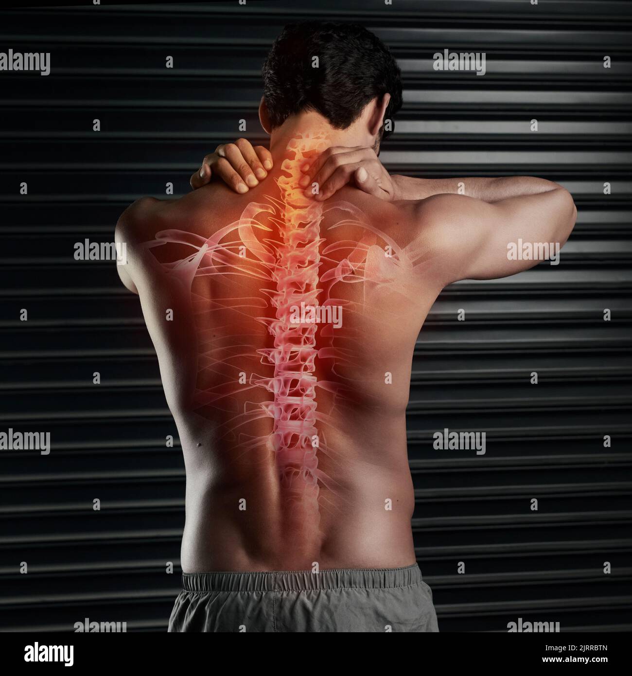 Dont risk a spinal injury. Studio shot of a muscular young man rubbing ...