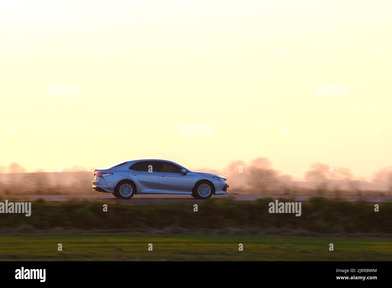 Car driving fast on intercity road at sunset. Highway traffic in ...