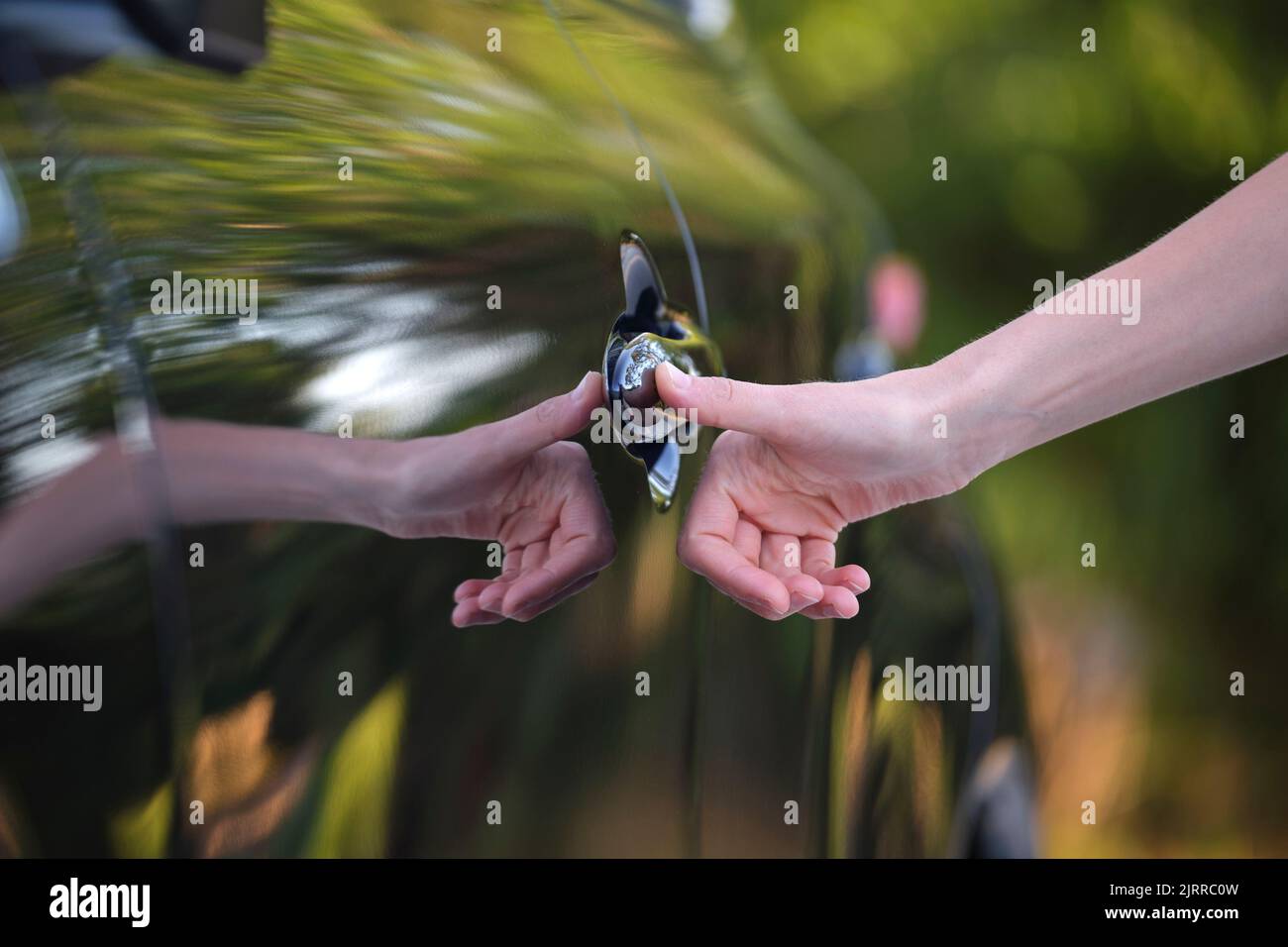 Closeup of driver hand opening car front door with touch ID finger ...