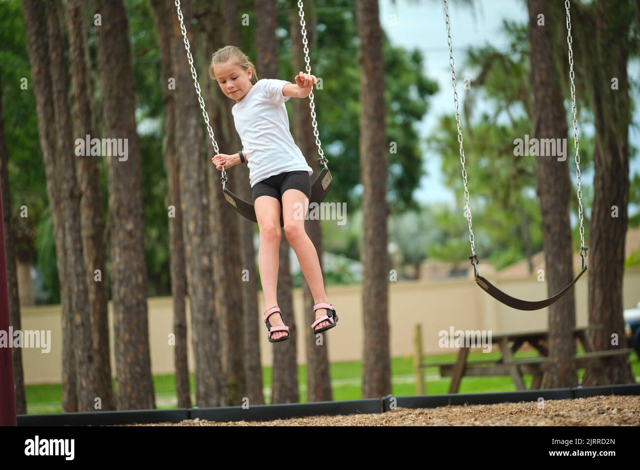 Young pretty excited teenage girl jumping out of the swings on summer ...