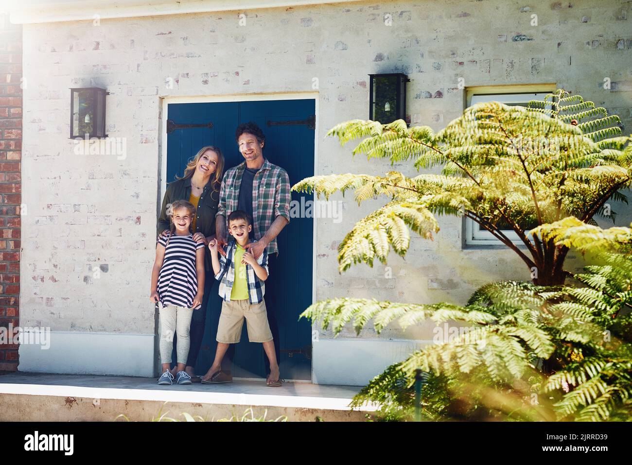 Welcome to our happy home. Portrait of a happy family standing outside ...