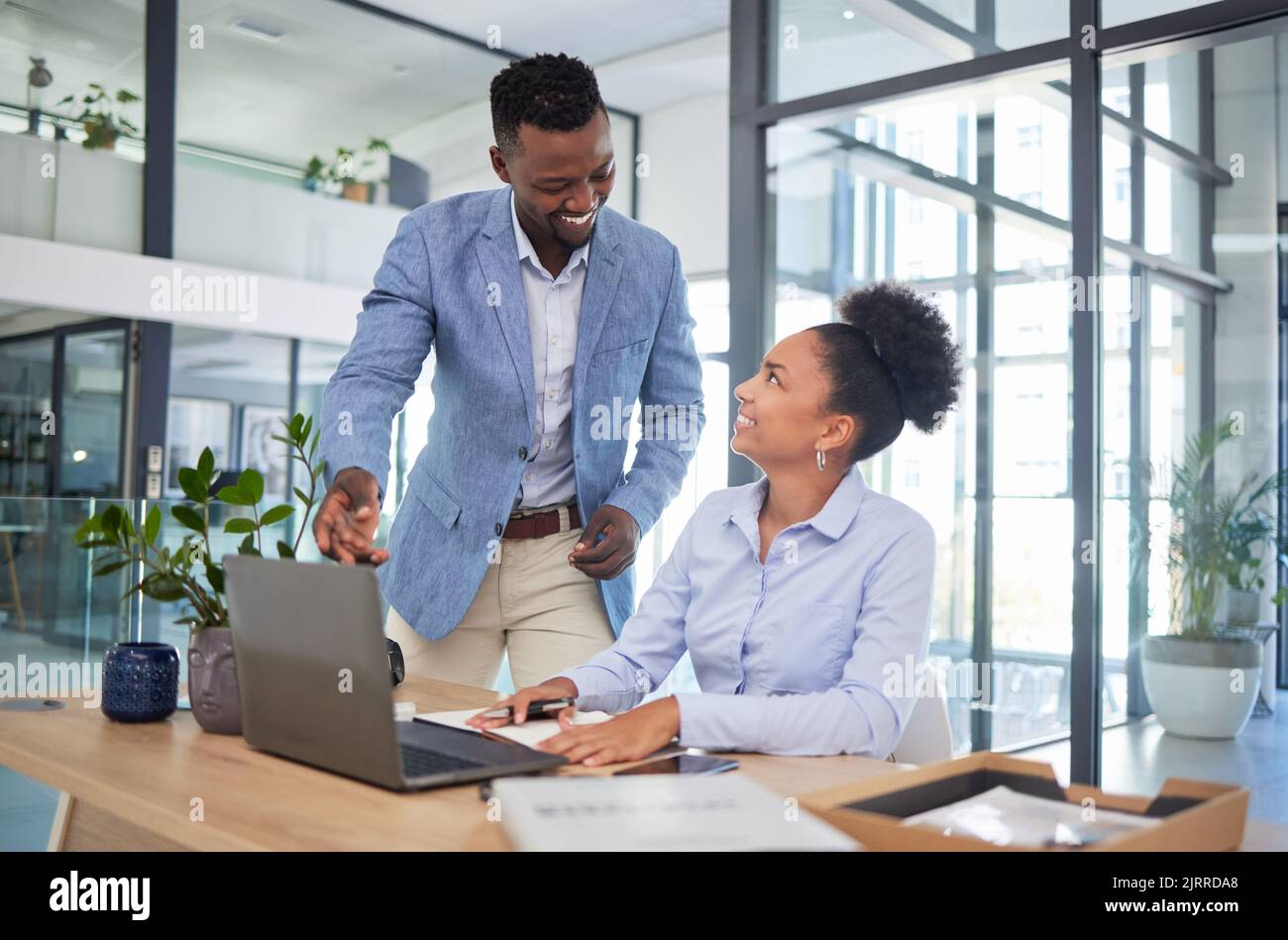 Training manager with laptop showing businesswoman how to use new ...