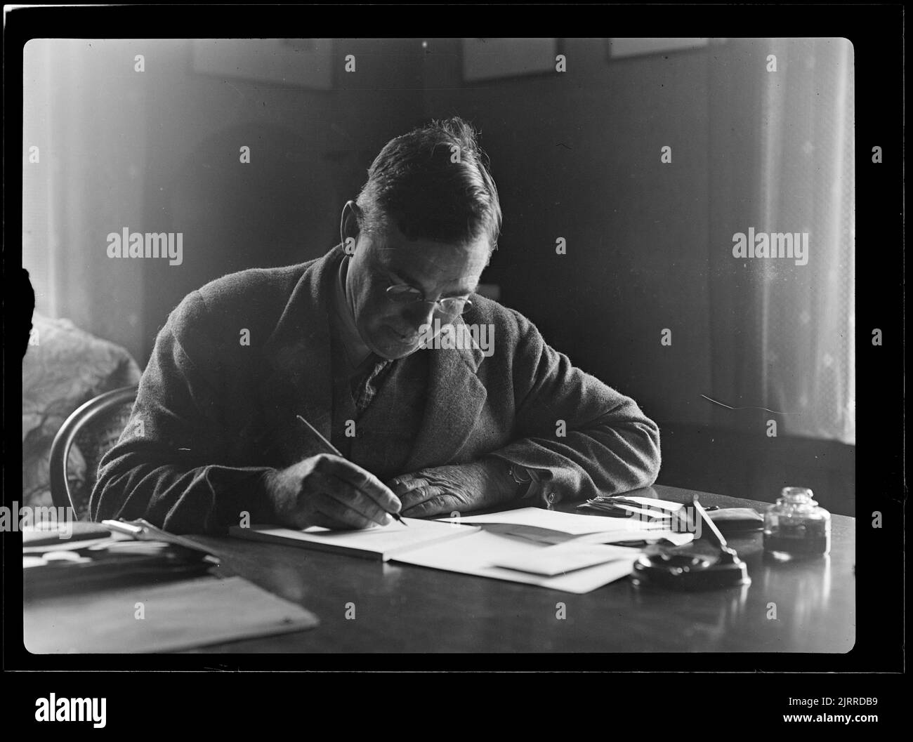 Man sitting table writing Black and White Stock Photos & Images - Alamy