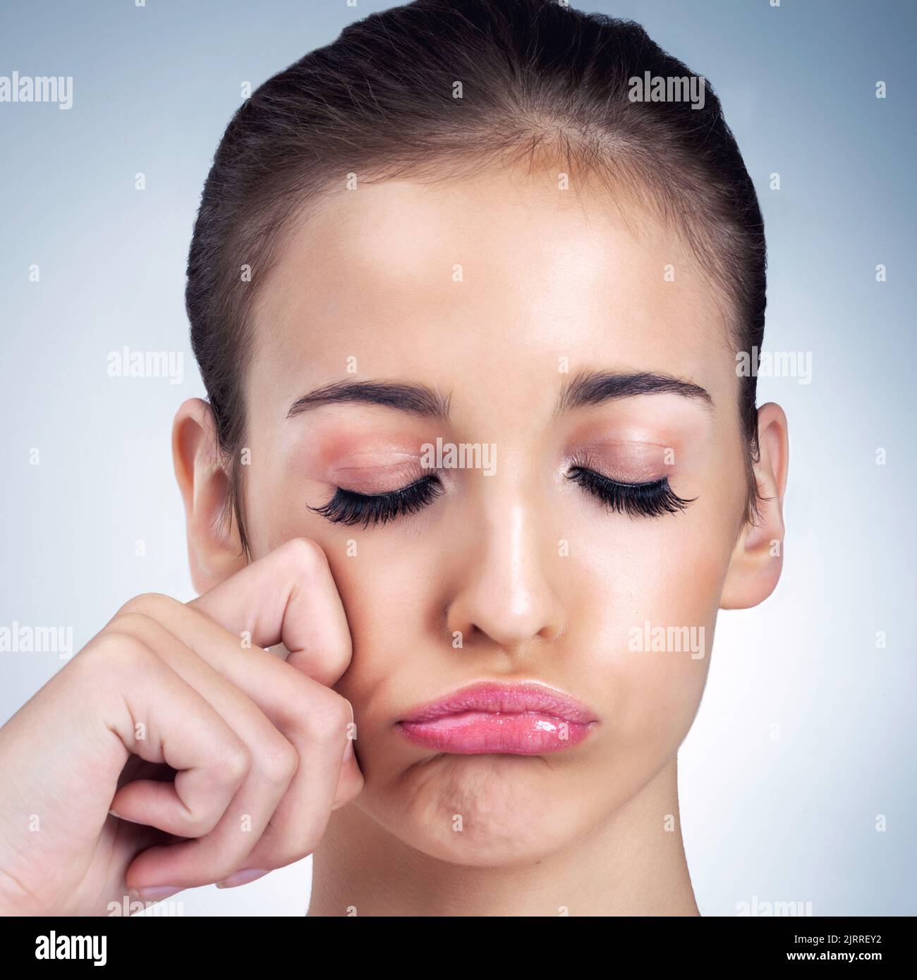 Feeling down. Studio shot of a beautiful young model posing against a ...