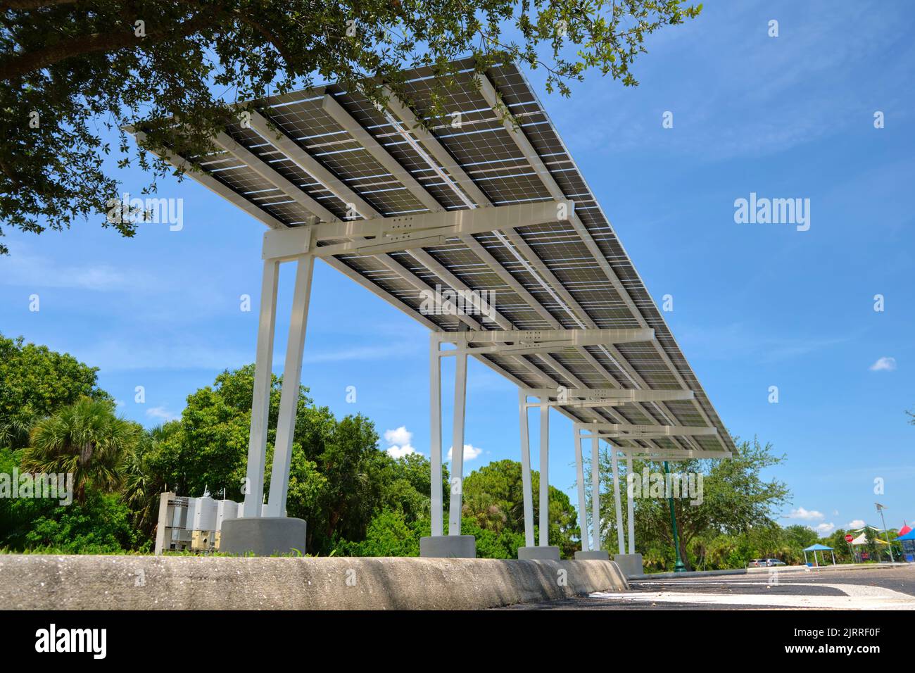 Solar panels installed as shade roof over parking lot for parked ...