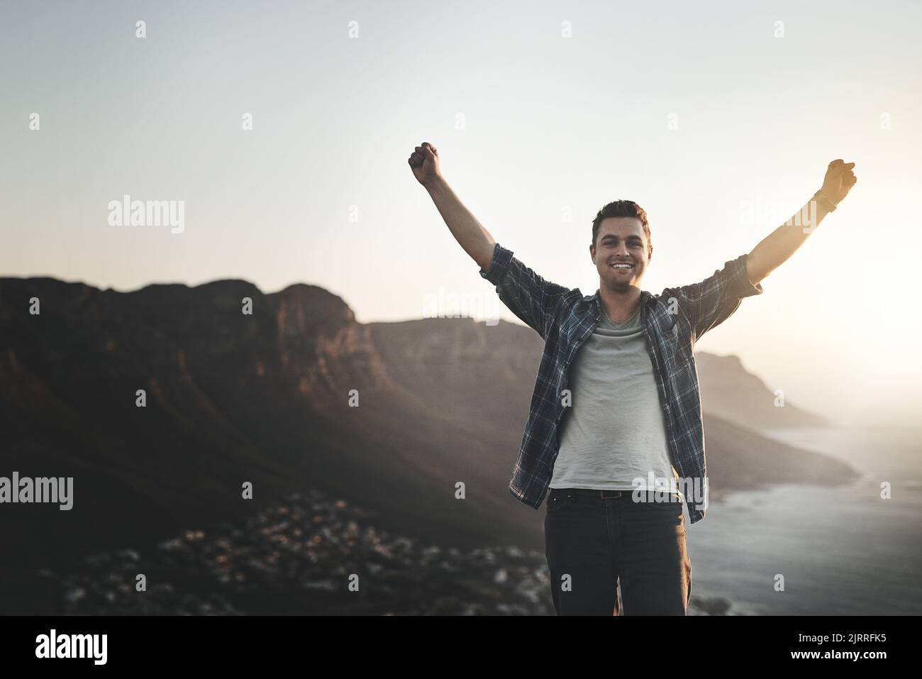 I conquered the mountain. Portrait of a young man standing on a ...