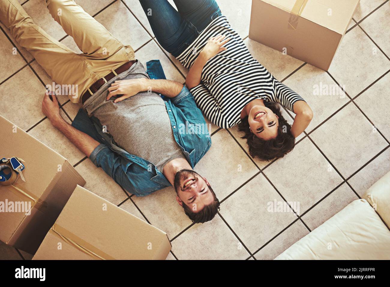 Packing sorted. Now to rest. a happy young couple relaxing on the floor ...