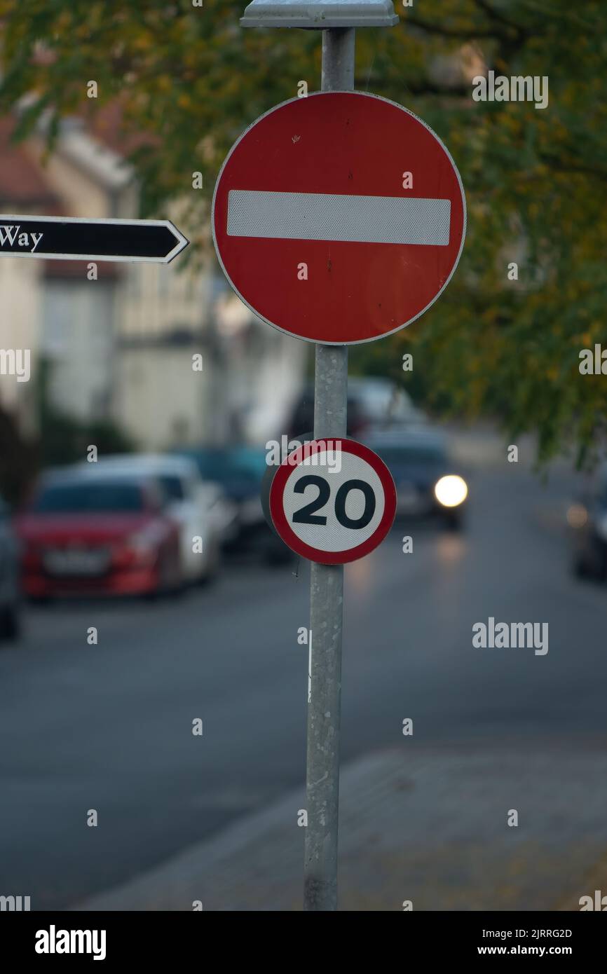 A circular signs showing No Entry and 20 mph limit with blurred street ...