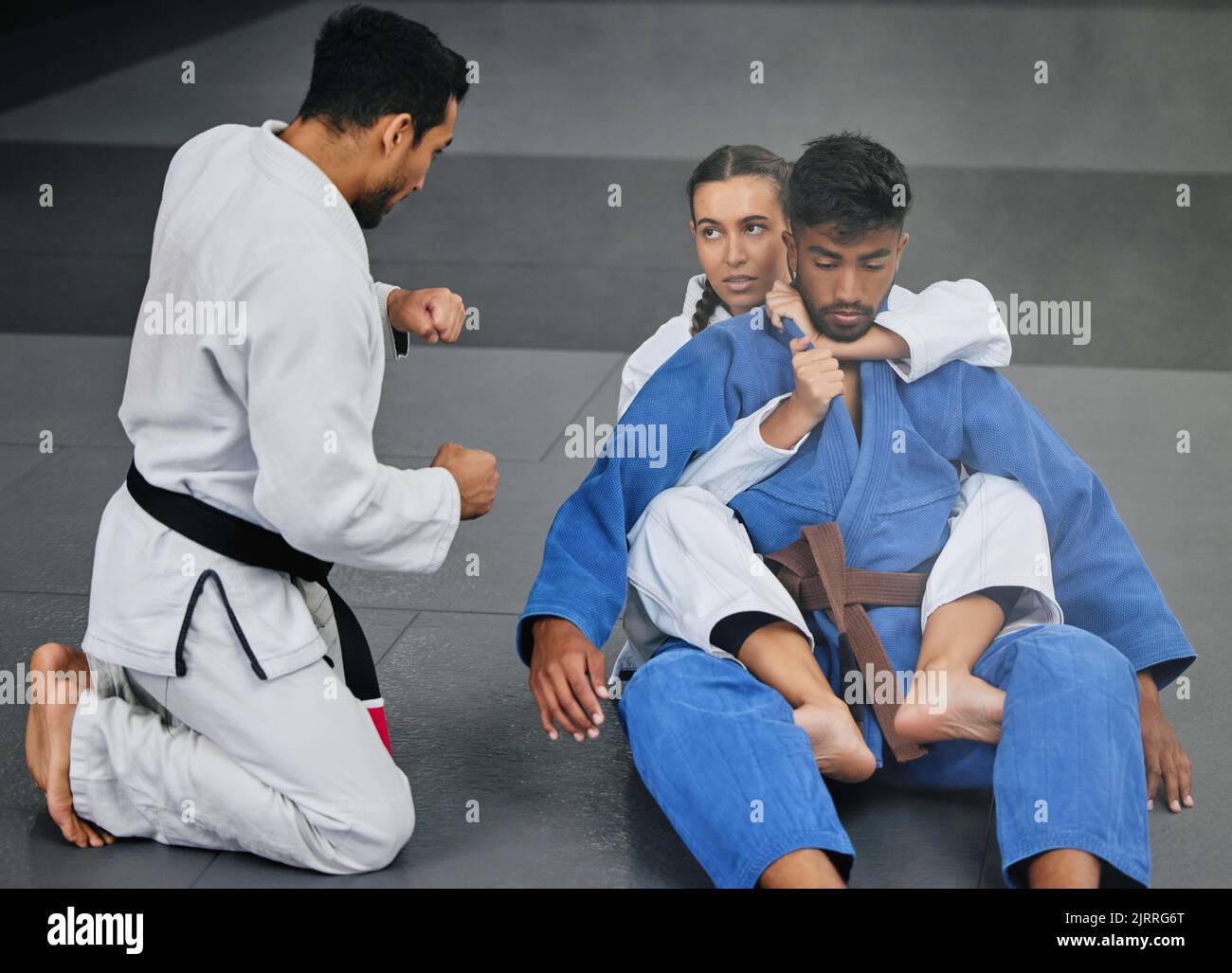 Karate training with trainer at a fitness studio, learning defense moves and practising fighting ...