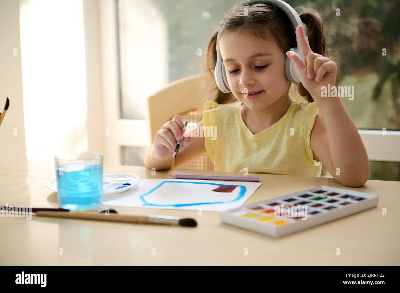 Beautiful little girl of preschool wearing wireless headphones ...