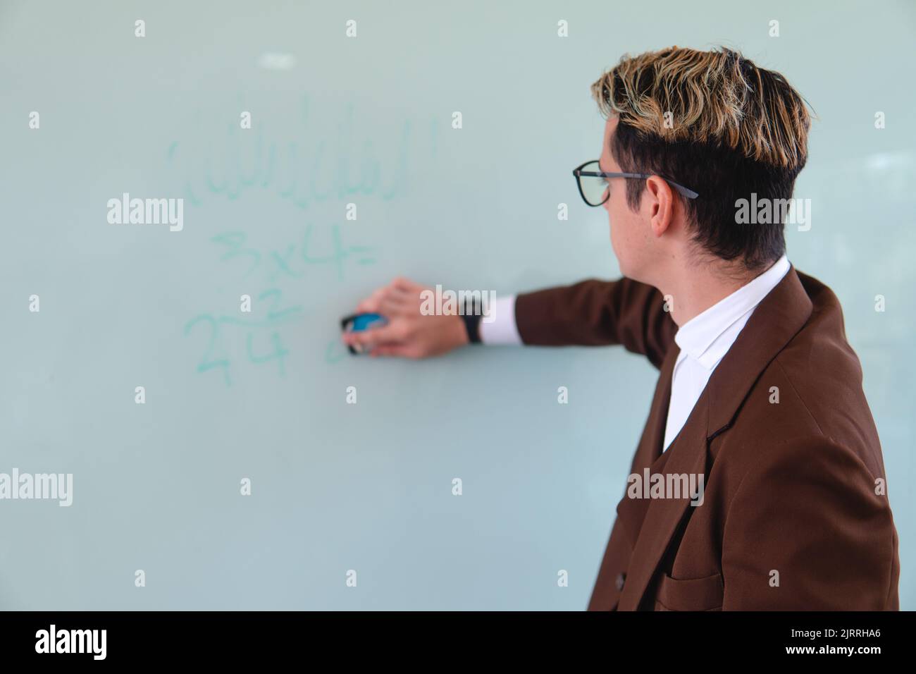 Teacher erasing the blackboard. Caucasian teacher, blond and smartly ...