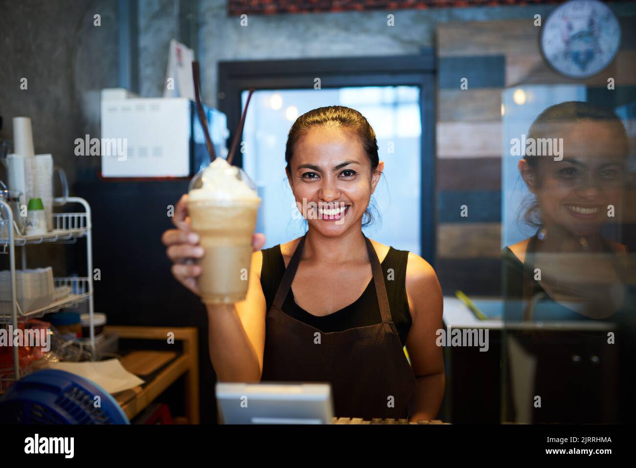 Expertly prepared, just for you. Portrait of a young barista holding up ...