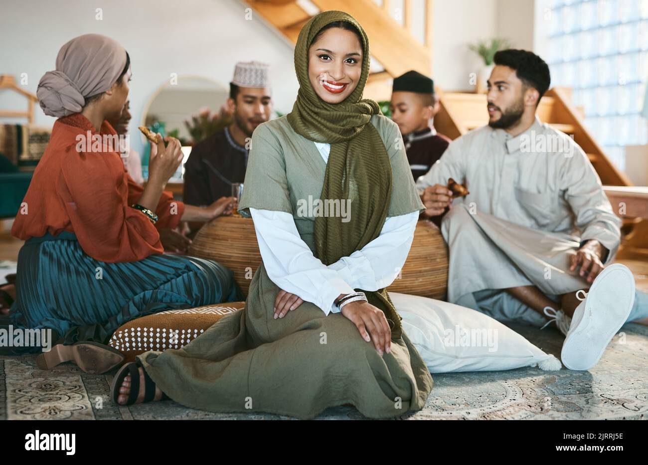 A happy Muslim woman sitting, with family and celebration of culture ...