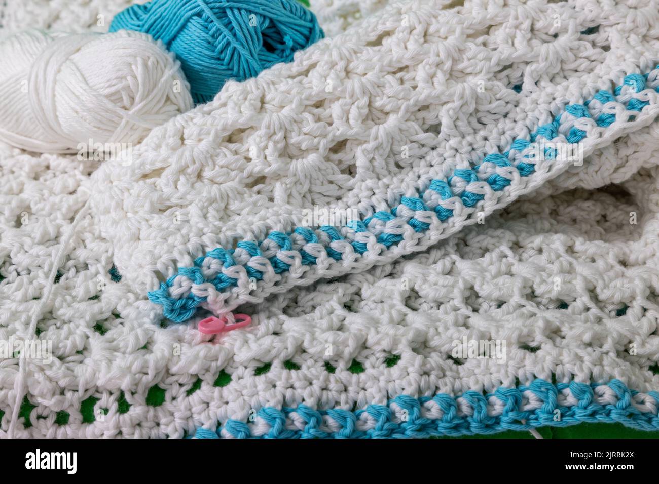 Unfinished white crochet blanket with blue details on the edges ...
