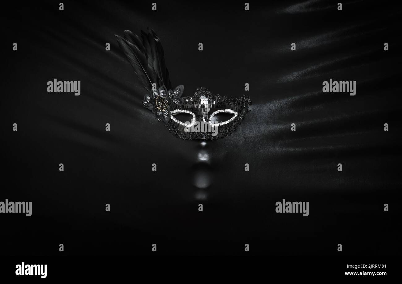 Fancy party mask with screaming human face press through black fabric ...