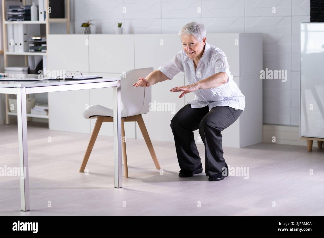 Female Doing Office Yoga Exercise Sit Up And Stretch At Desk Stock ...