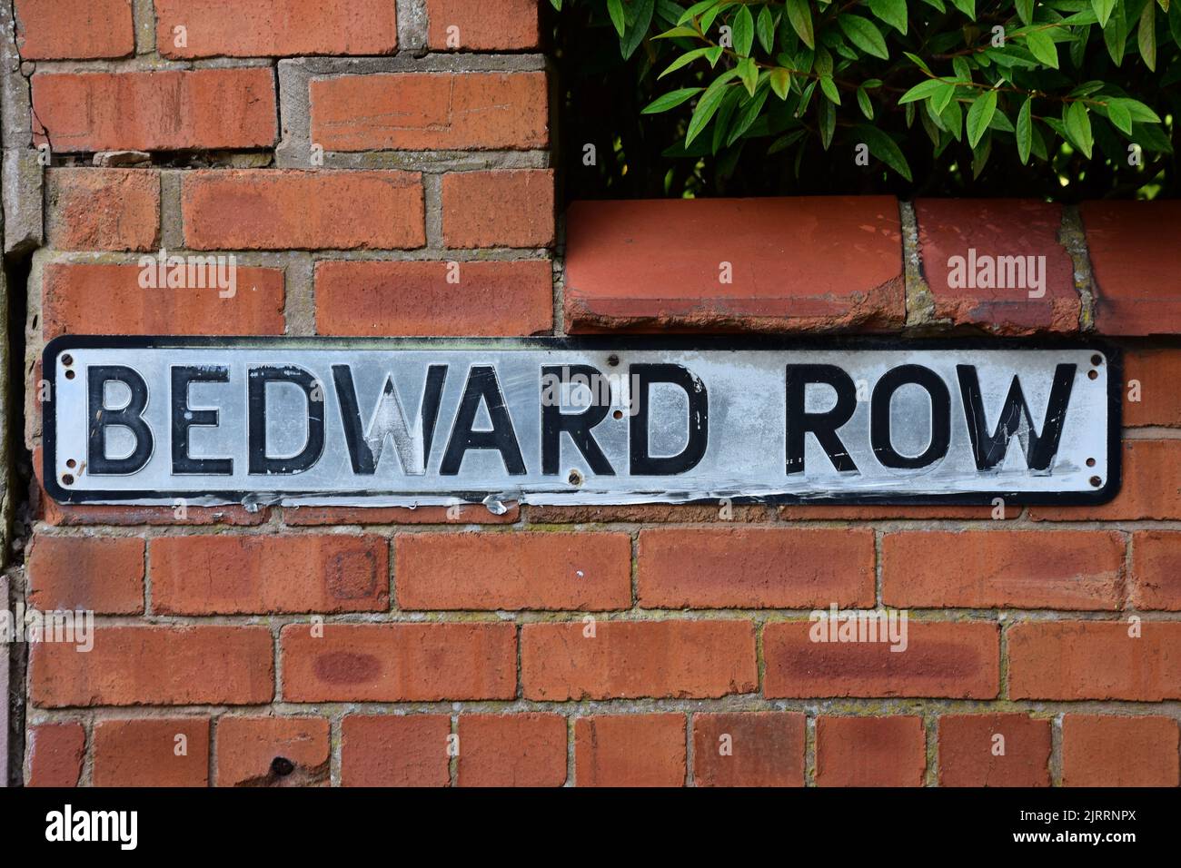 A faded street name sign for Bedward Row mounted on a red brick wall ...