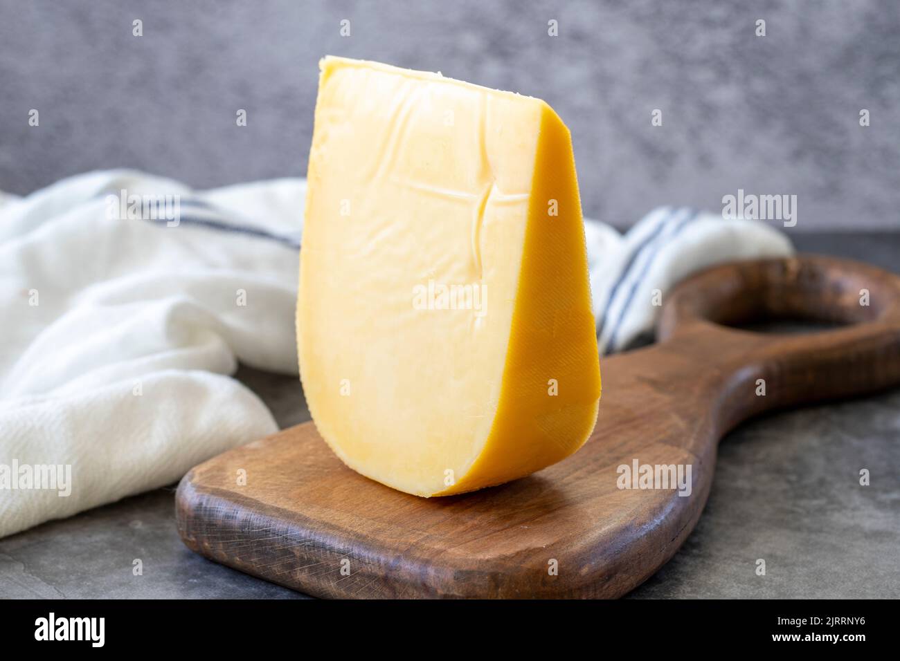Yellow gouda cheese. Hard Dutch gouda cheese, on dark background. close ...