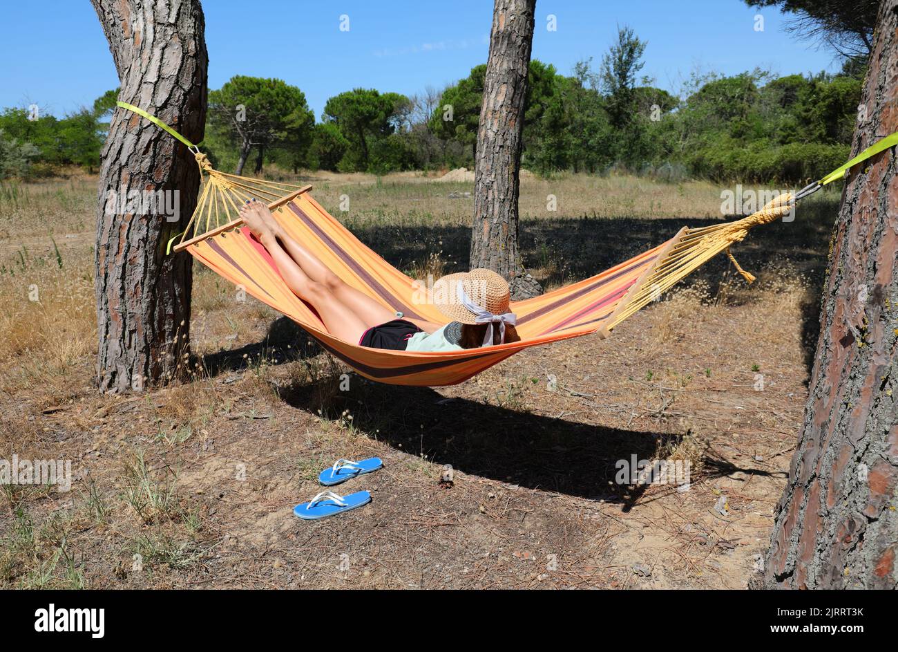 Girl with straw hat on posen swinging on hammock in summer Stock Photo ...