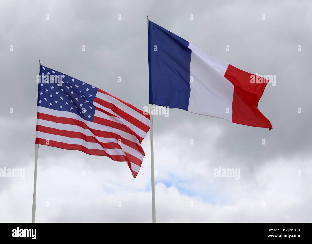 Waving large flags of the United States of America and France on a blue ...