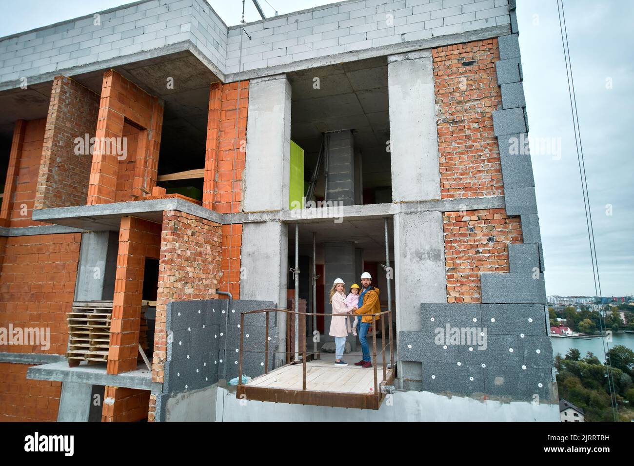 Man with wife and child standing inside residential building under ...
