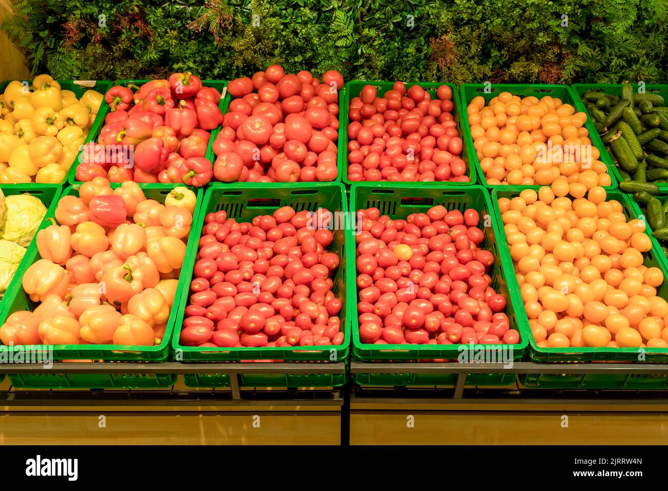 Supermarket vegetables background. Fresh tomatoes and peppers in boxes on the supermarket ...