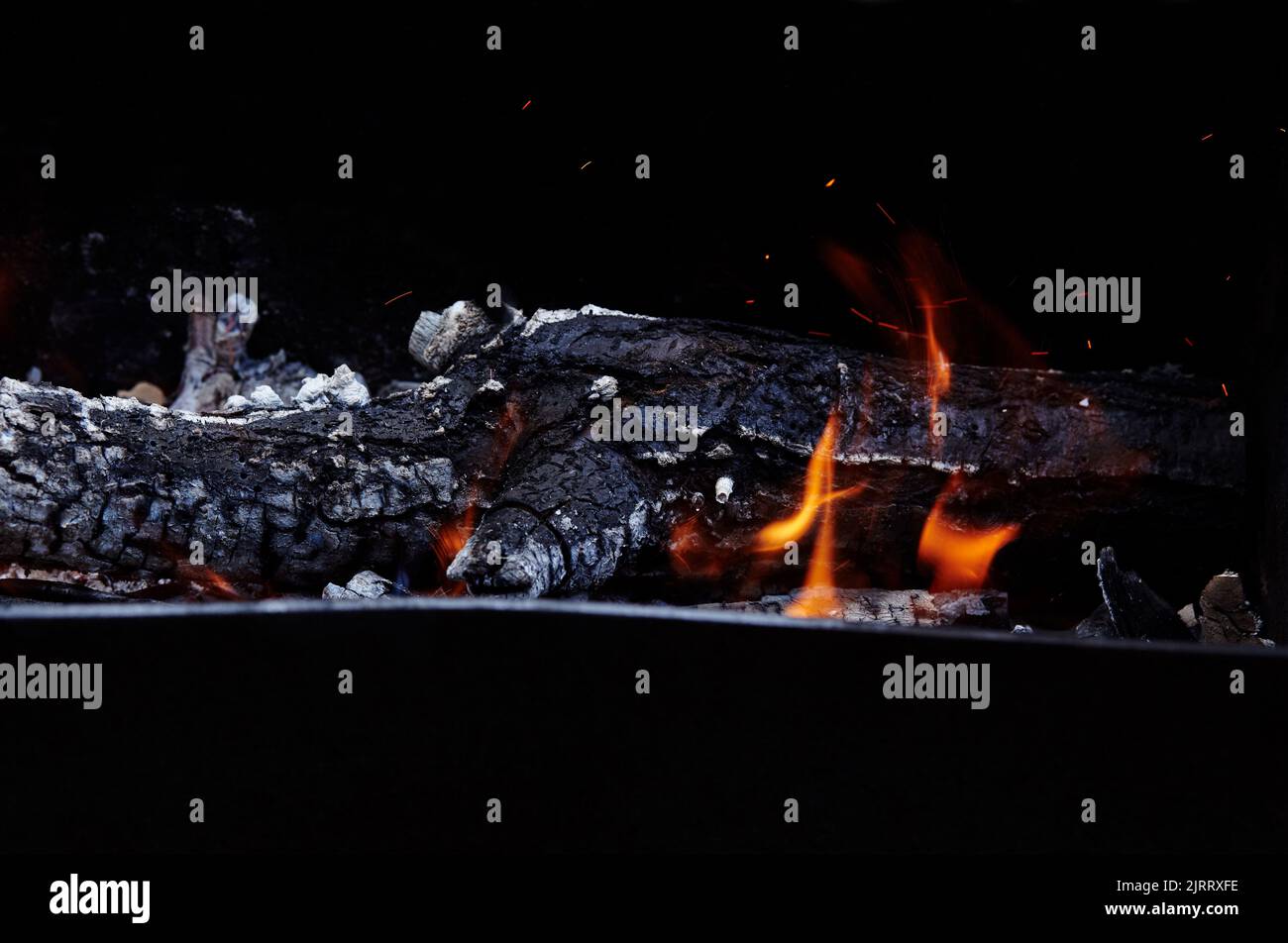 Burning red hot sparks fly from fire. Barbecue gril with glowing and ...