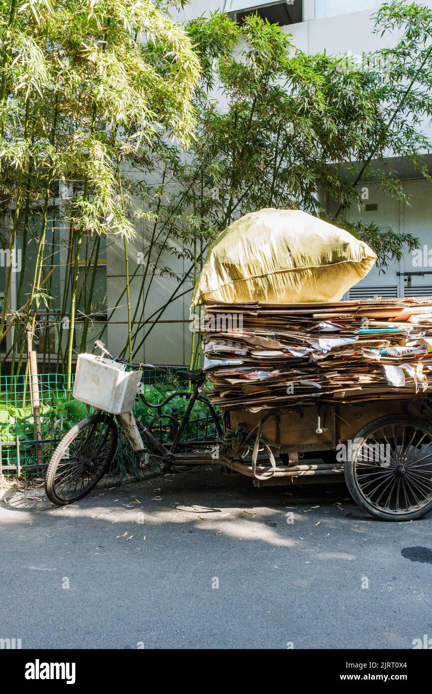 A vertical shot of a typical garbage collector bike full of cardboard ...