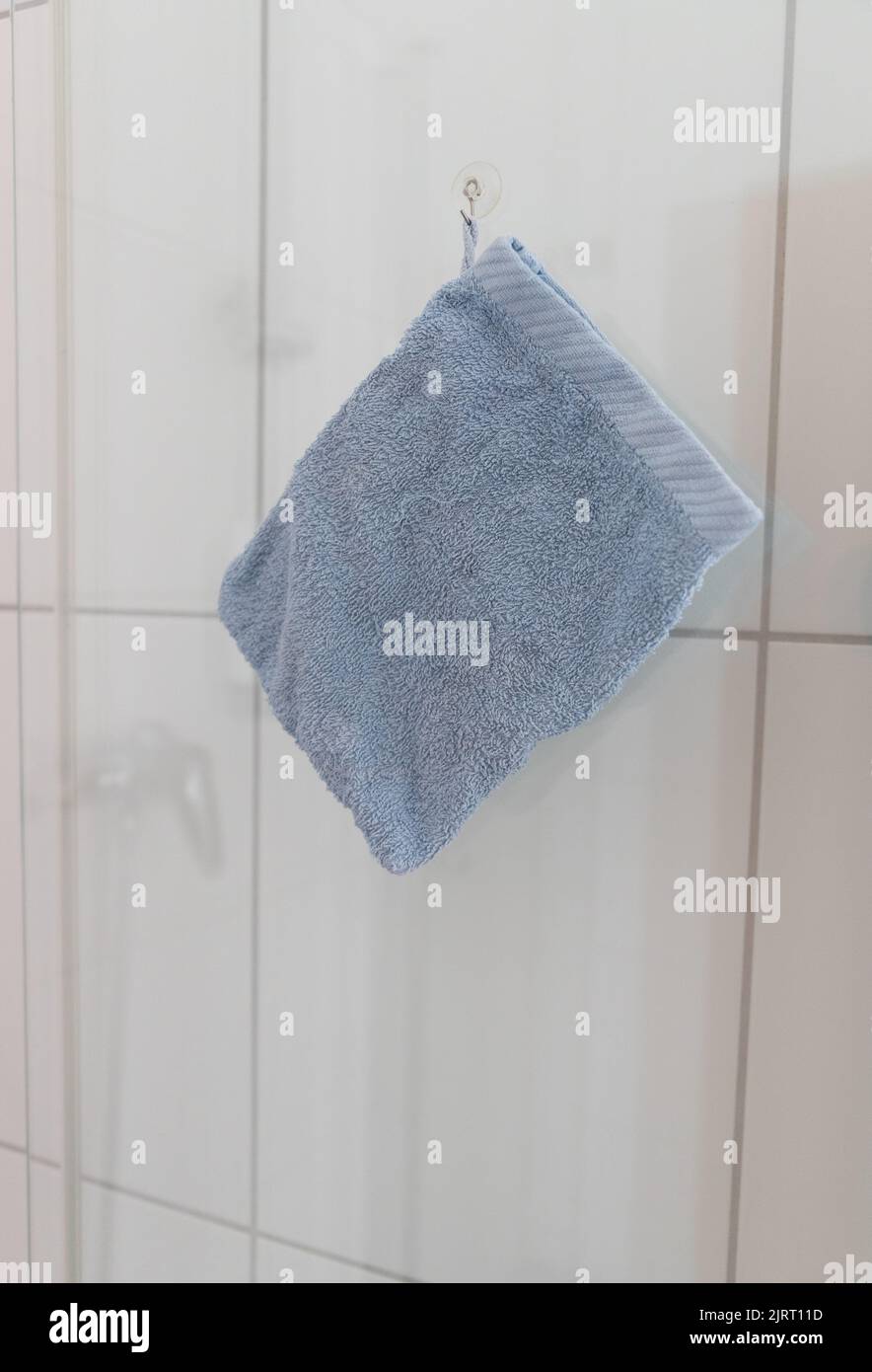 a blue washcloth is hanging in a bathroom on a glass door Stock Photo ...
