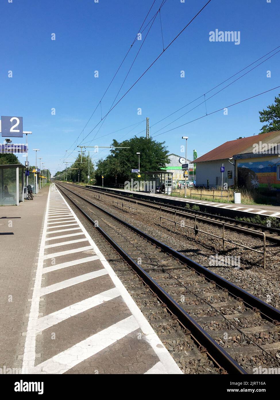 A railroad seen from a small train station. Two tracks Stock Photo - Alamy