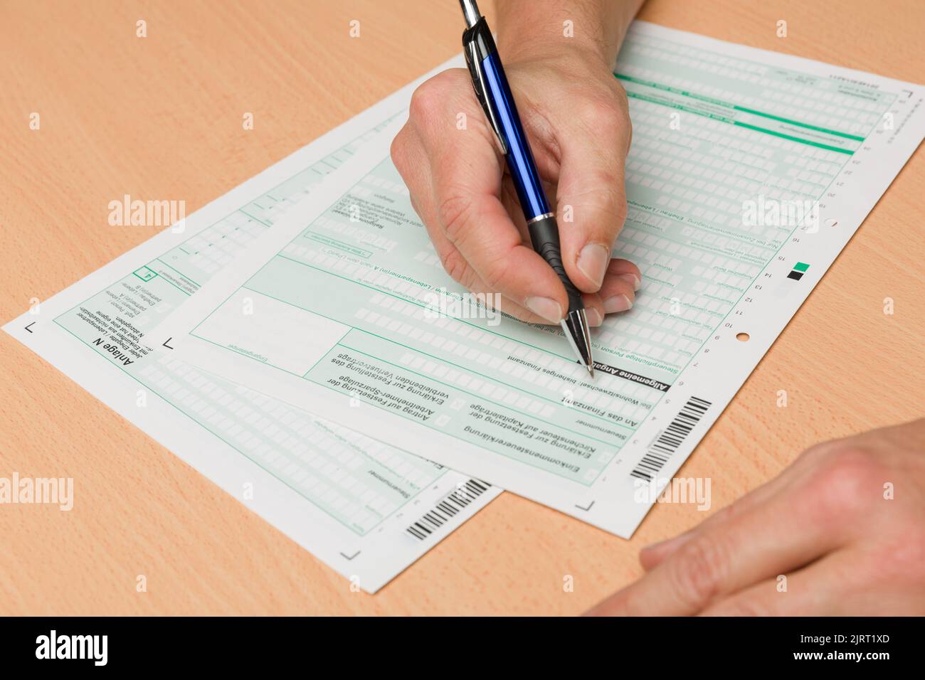 Close-Up of man's hand fill out a tax declaration or tax return with ...