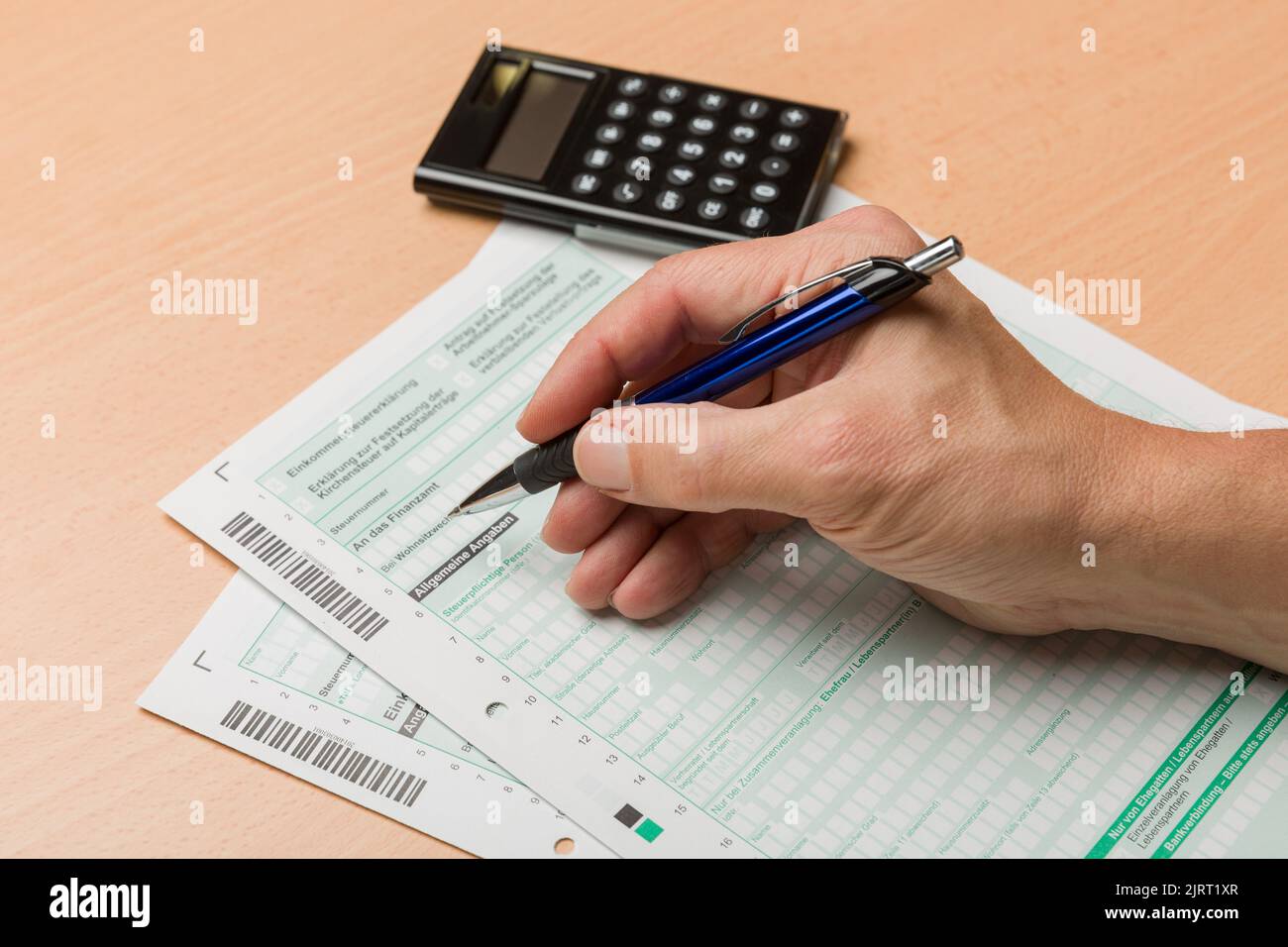 Close-Up of man's hand fill out a tax declaration or tax return with ...
